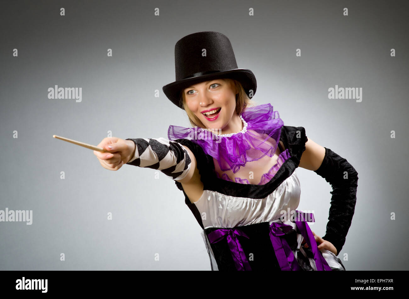 Woman magician doing her tricks with wand Stock Photo - Alamy