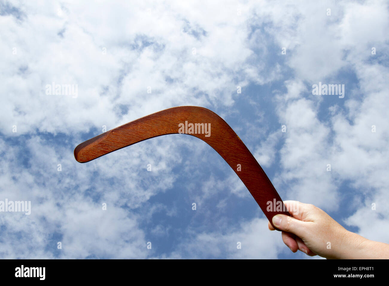 Wooden boomerang in hand with blue sky and cloud background Stock Photo ...