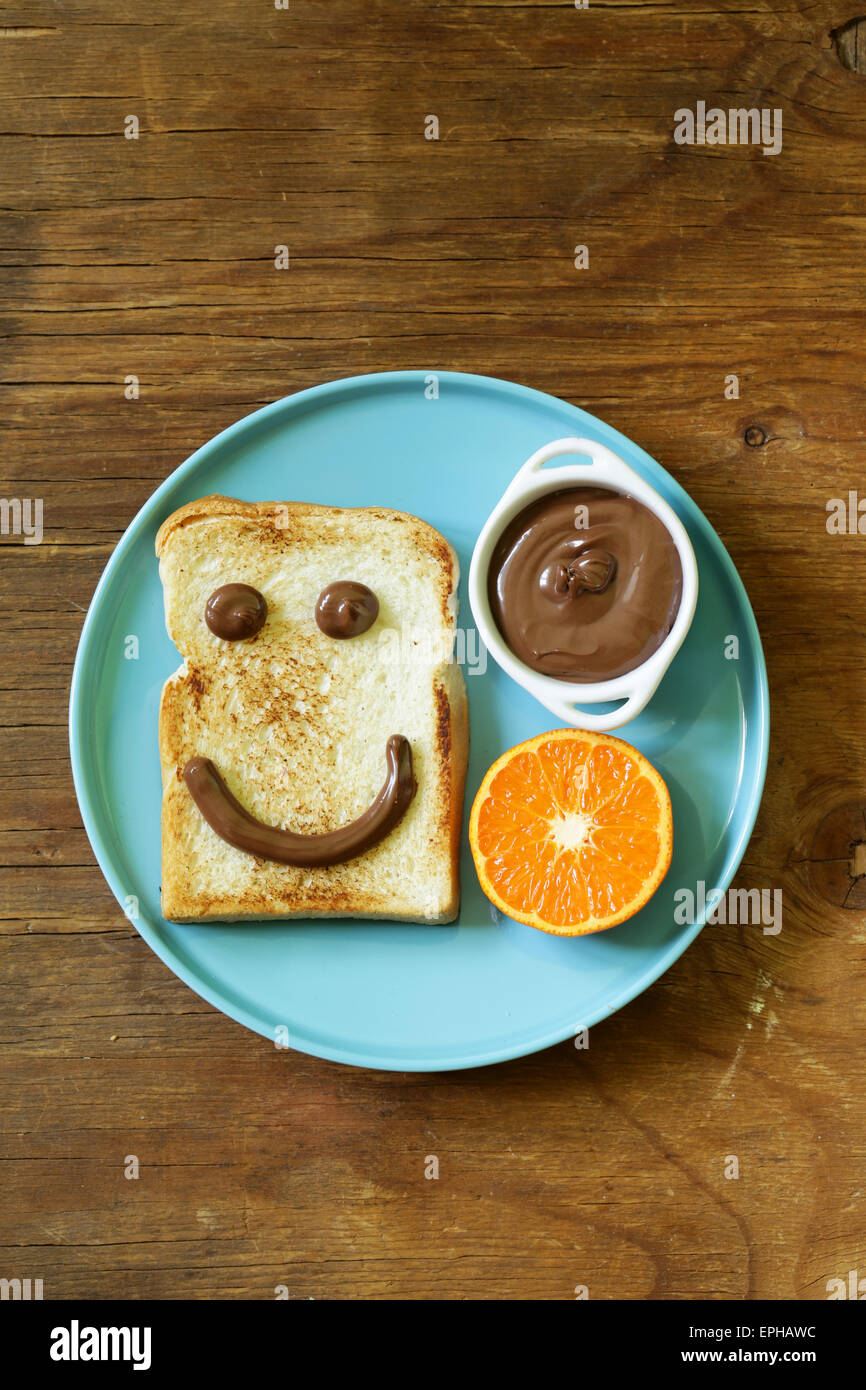 breakfast serving funny face on the plate (toast, chocolate spread and ...