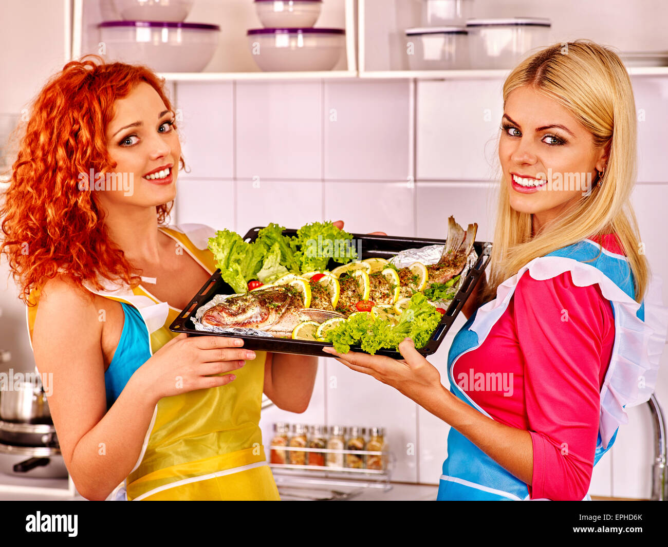 Women prepare fish in oven Stock Photo - Alamy