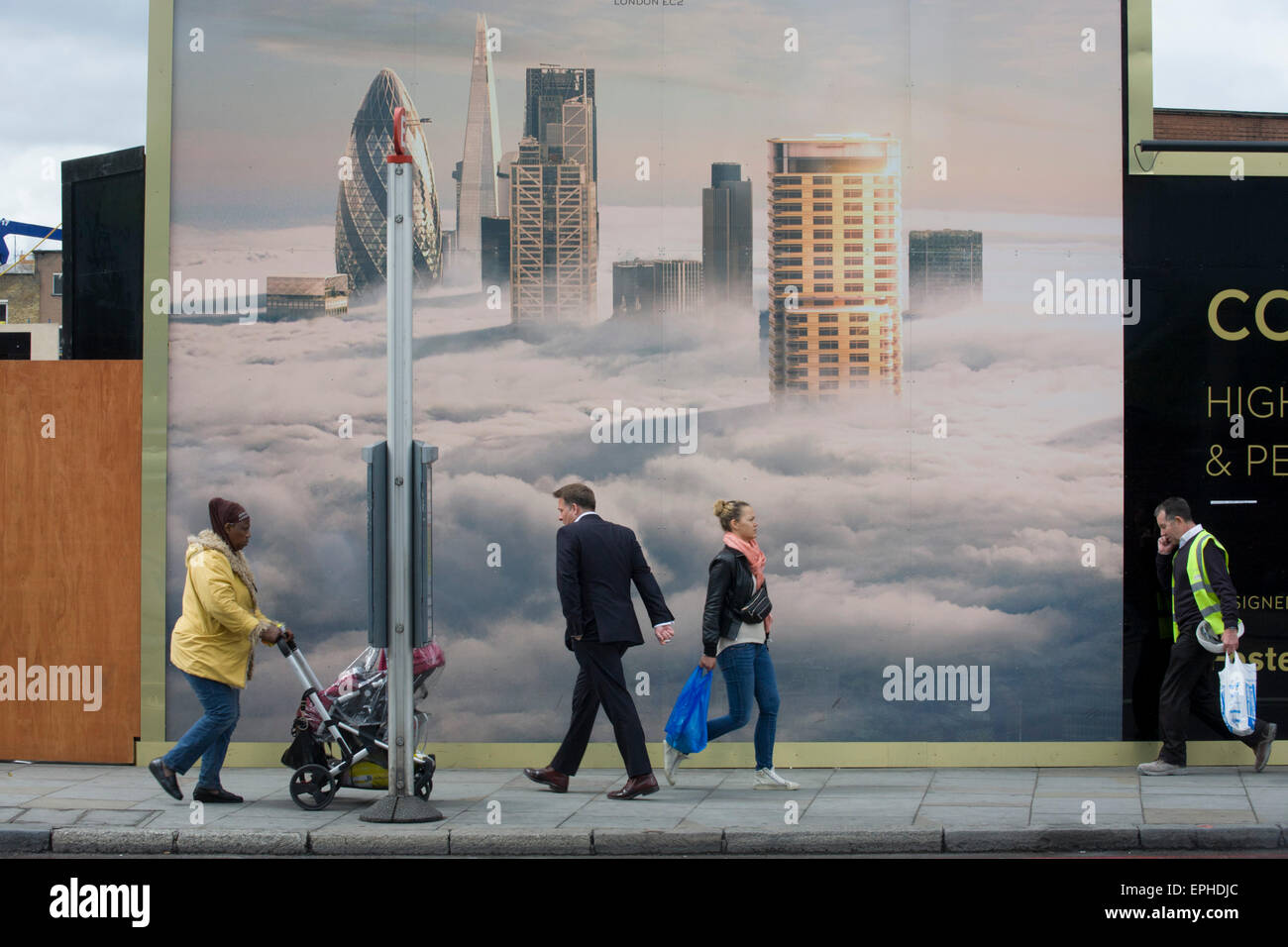 People walk beneath a property developer's billboard showing a large ...