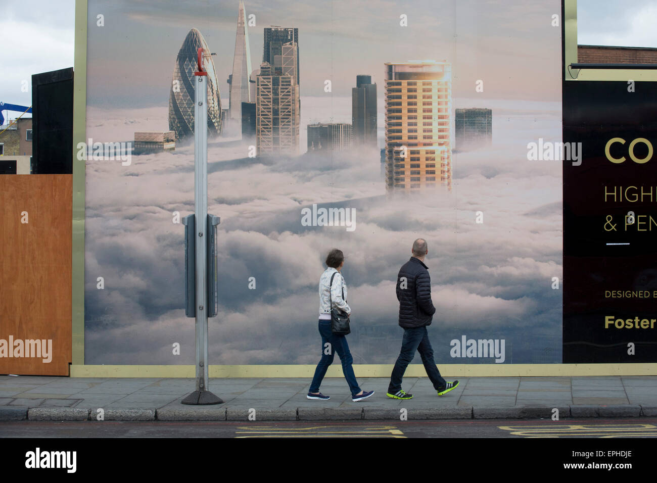 People walk beneath a property developer's billboard showing a large ...