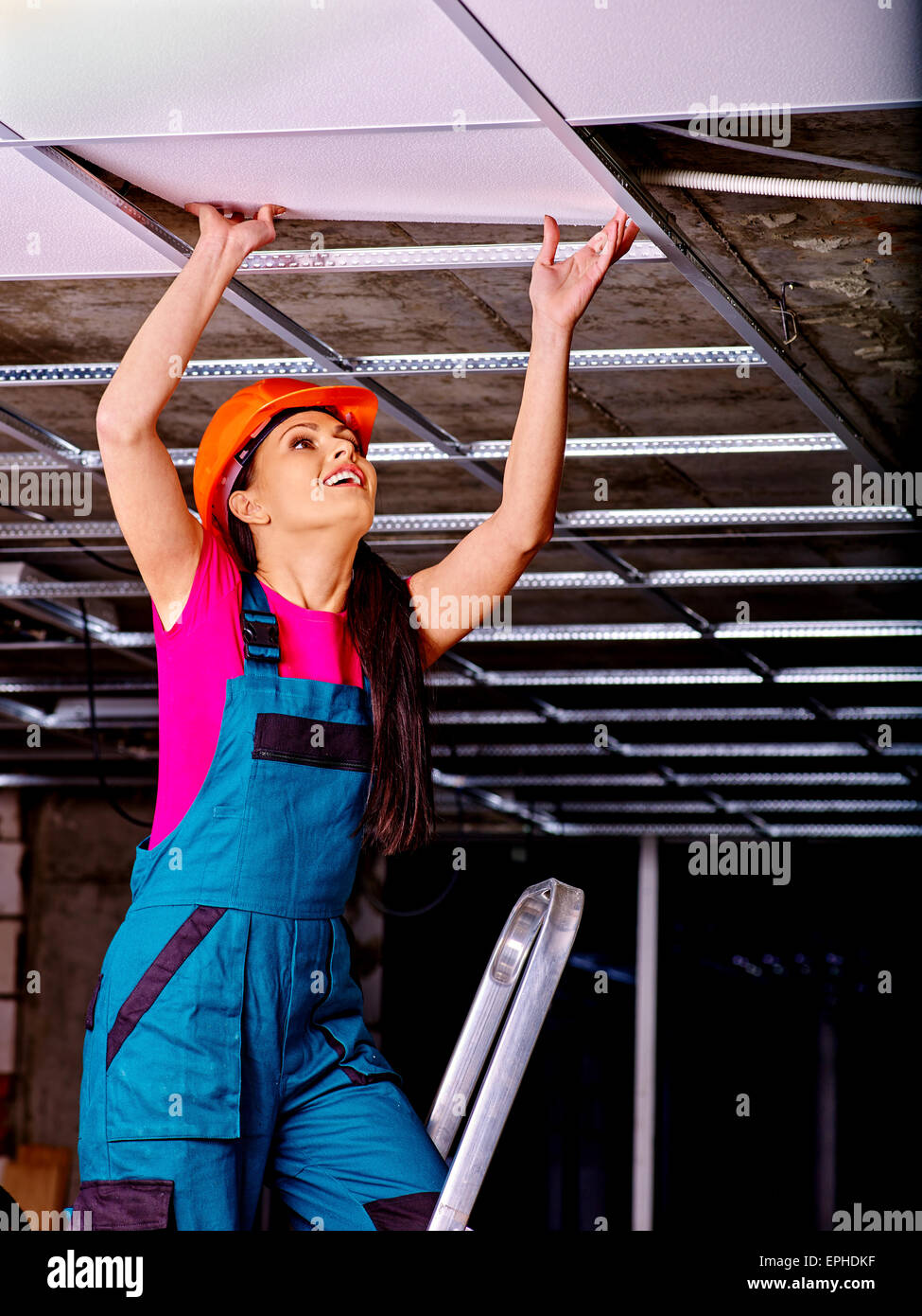Woman installing suspended ceiling Stock Photo - Alamy