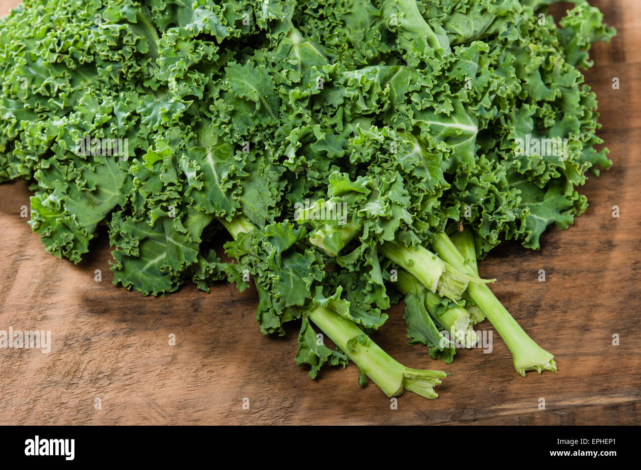 Fresh green curly kale leaves on a table Stock Photo - Alamy