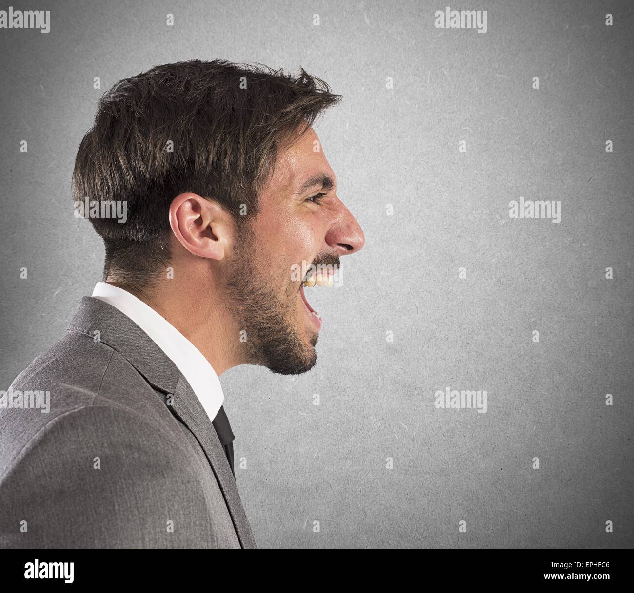 Businessman explodes in a scream Stock Photo - Alamy
