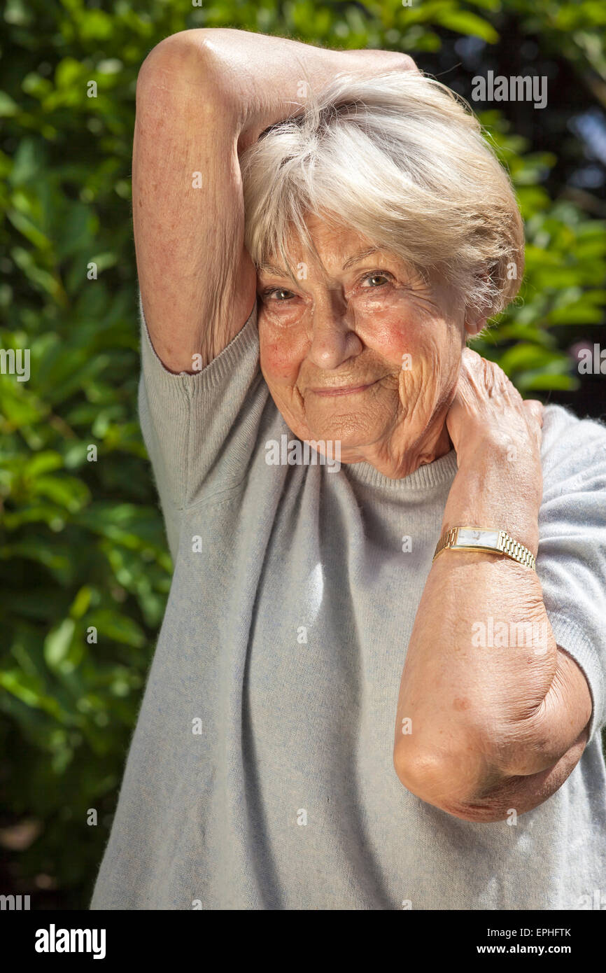 Positive confident elderly woman with a warm friendly smile standing ...