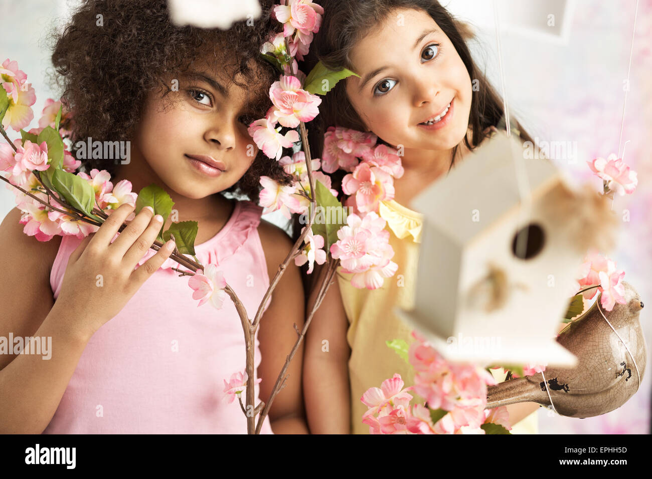 Two cute girls with beautiful pink flowers Stock Photo - Alamy