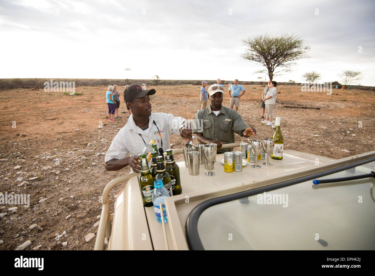 Africa, Namibia. AfriCat Foundation. Tour guides preparing drinks for ...