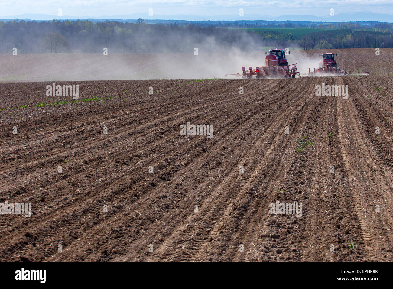 The tractor harrowing the large brown field in spring season Stock ...