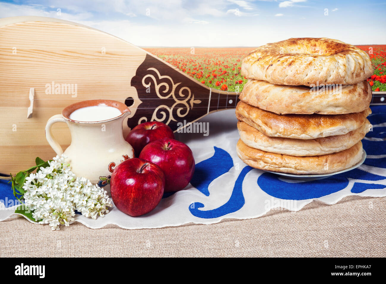 Dombra Kazakh instrument, apples, milk and bread lepeshka on the table ...