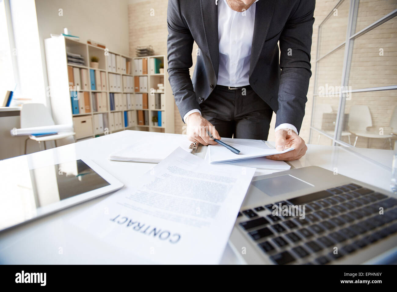 Elegant employee reading business contract in office Stock Photo - Alamy