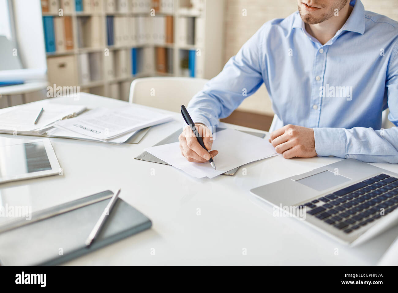 Businessman with pen writing down his ideas on paper Stock Photo - Alamy