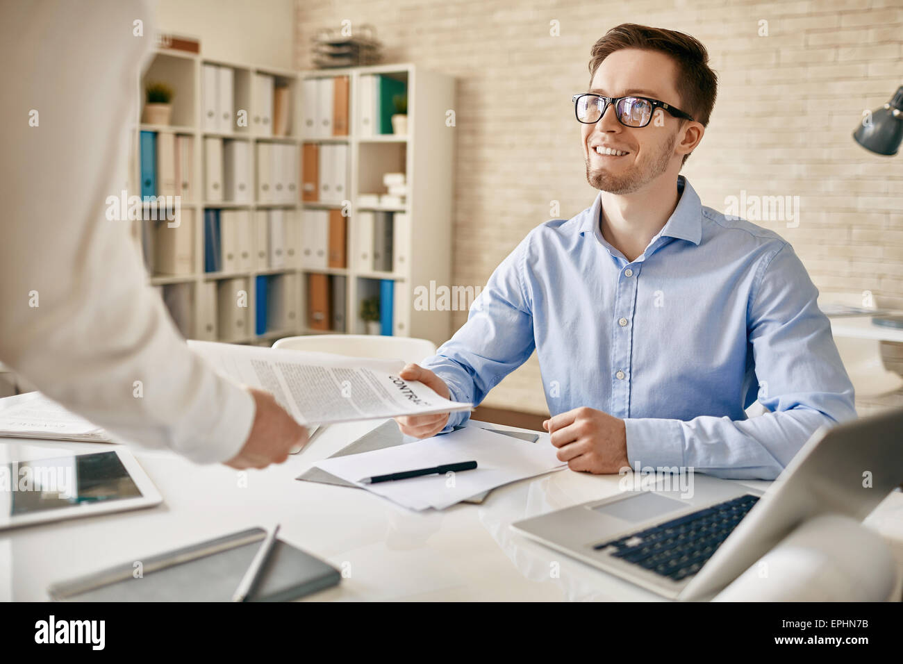 Businessman giving contract to his colleague in office Stock Photo - Alamy