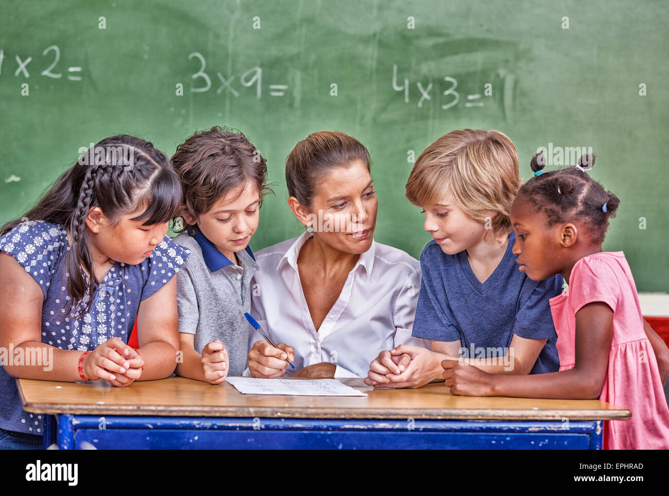 Female teacher with her multi ethnic classroom learning math Stock ...