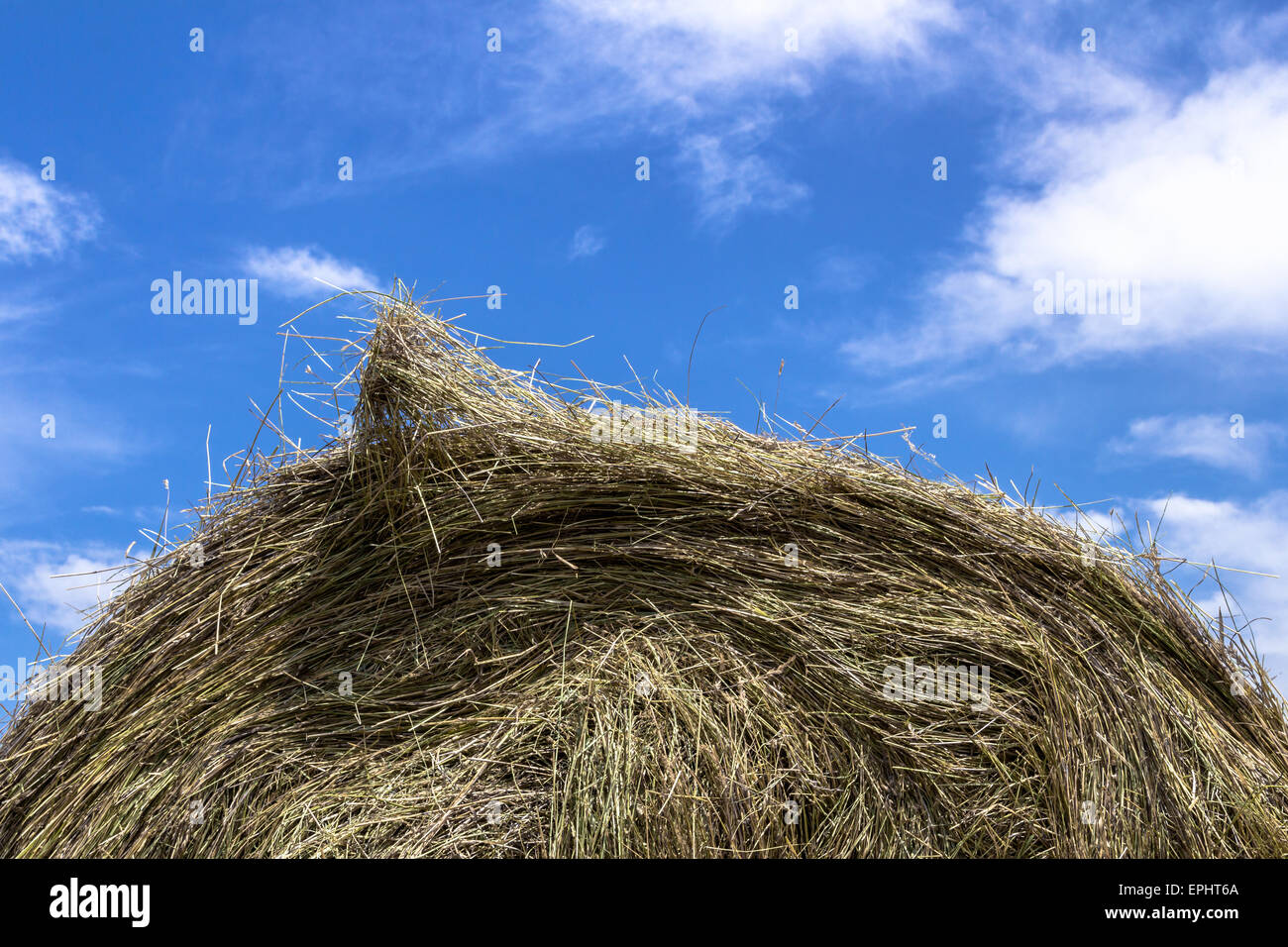Close up top of a bale of hay with blue sky and clouds in the ...