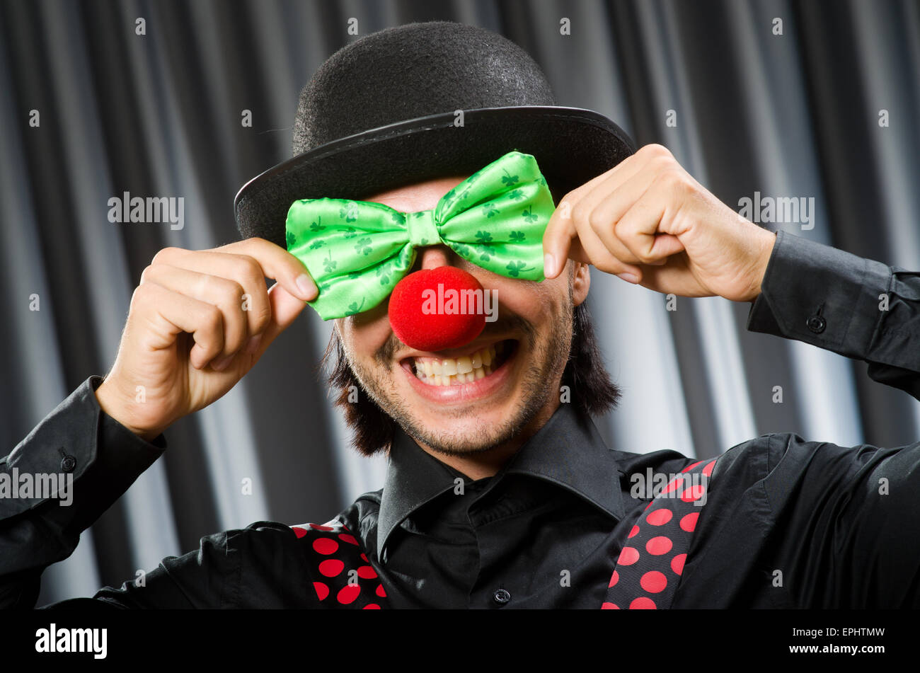 Funny clown in humorous concept against curtain Stock Photo - Alamy