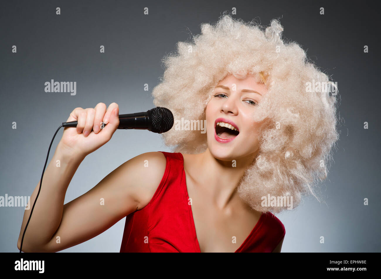 Young woman with mic in music concept Stock Photo - Alamy