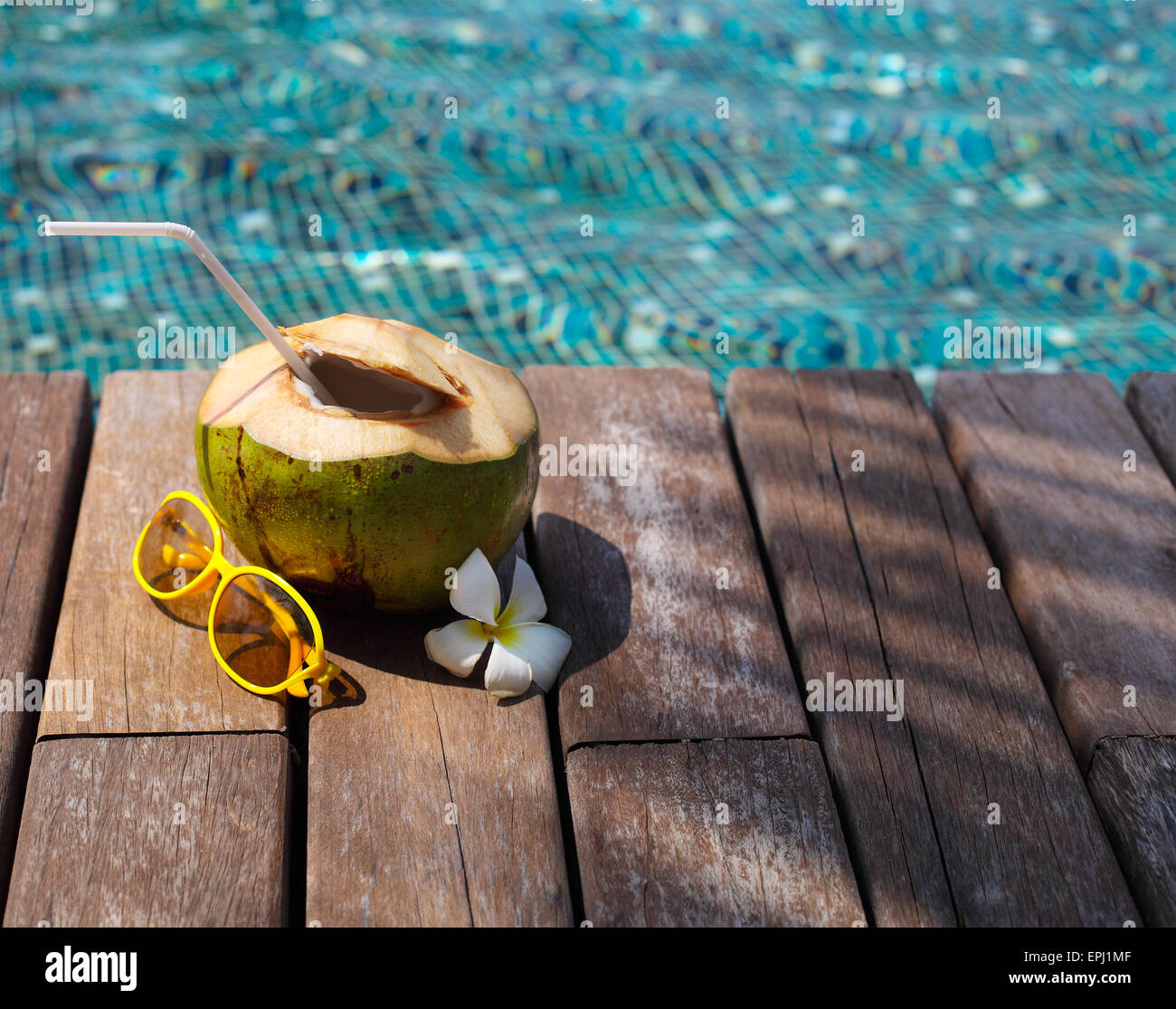 Coconut cocktail with drinking straw by the swimming pool Stock Photo ...