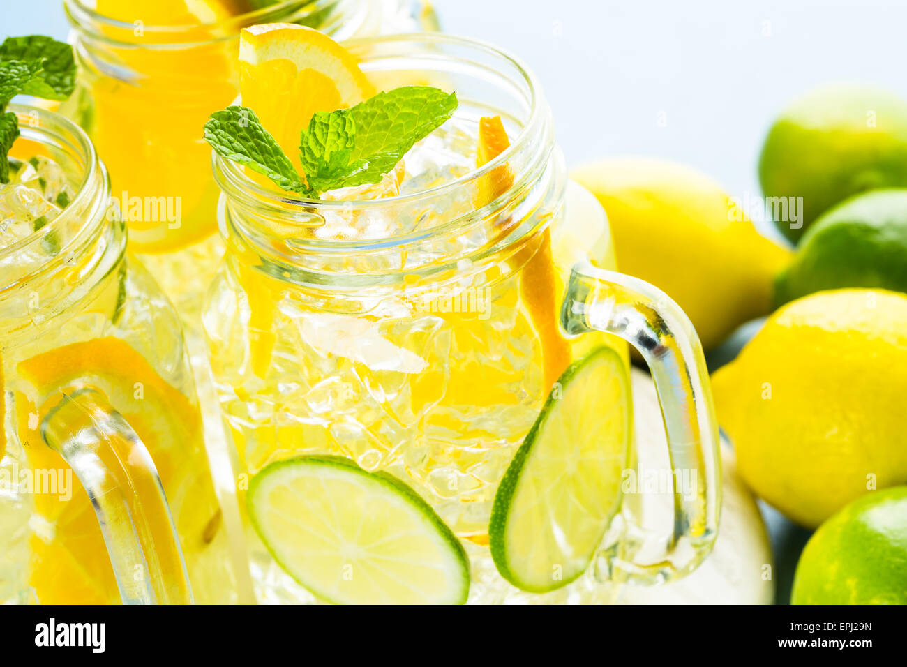 Infused water with fresh citrus fruits and ice Stock Photo - Alamy