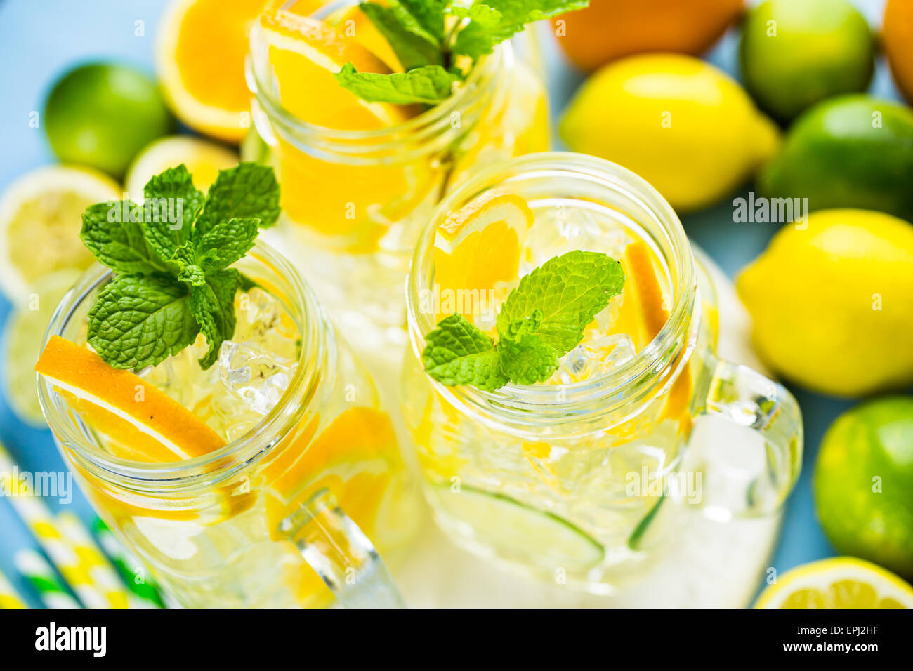 Infused water with fresh citrus fruits and ice Stock Photo - Alamy