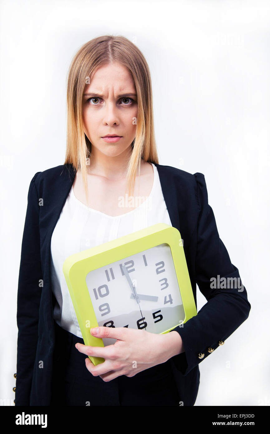 Serious businesswoman holding big clock over gray background and ...