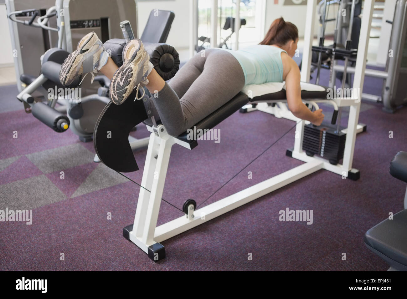 Fit brunette using weights machine for legs Stock Photo - Alamy