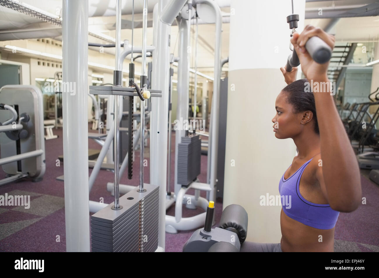Fit woman using the weights machine for her arms Stock Photo - Alamy