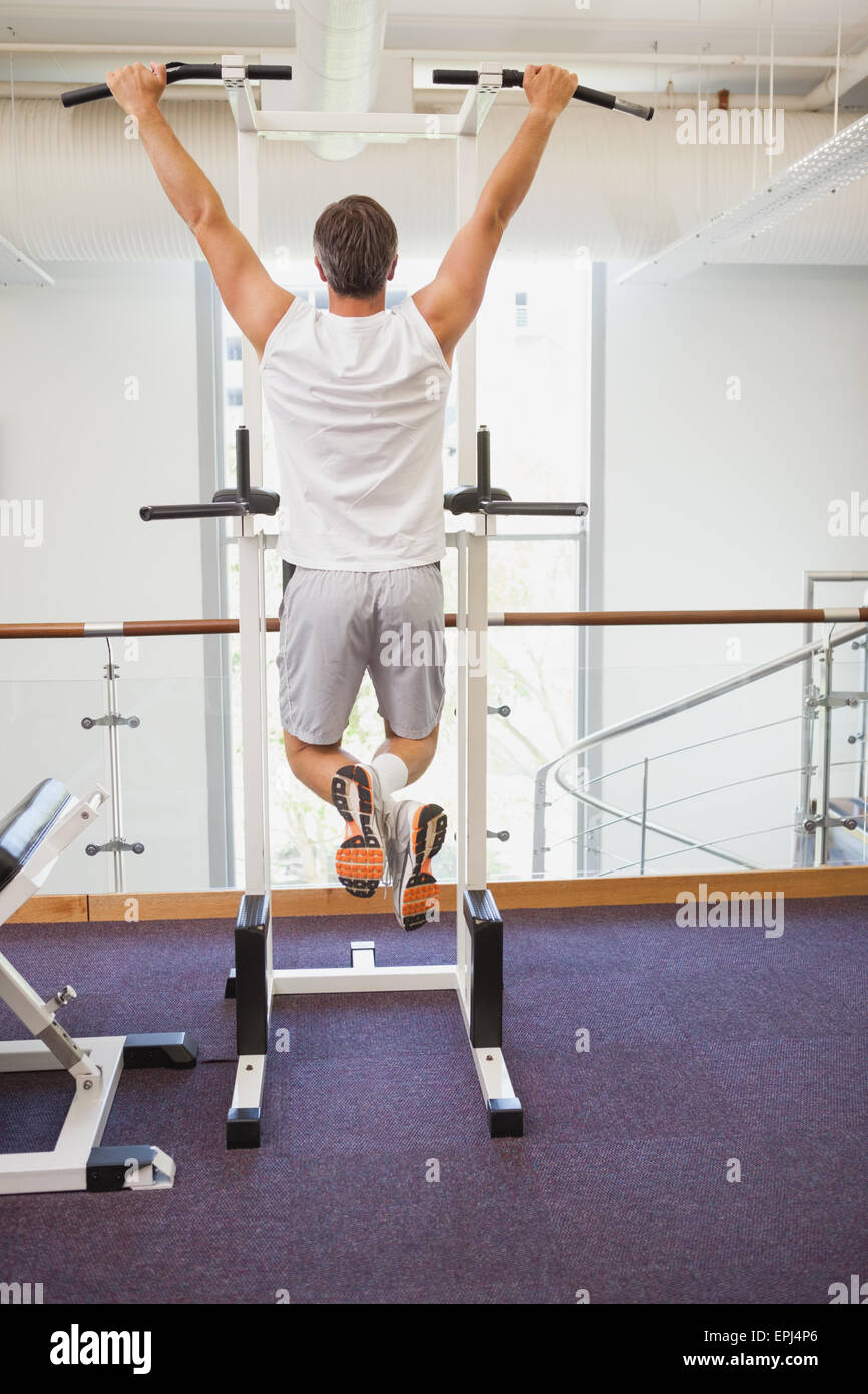 Fit man doing pull ups in fitness studio Stock Photo - Alamy