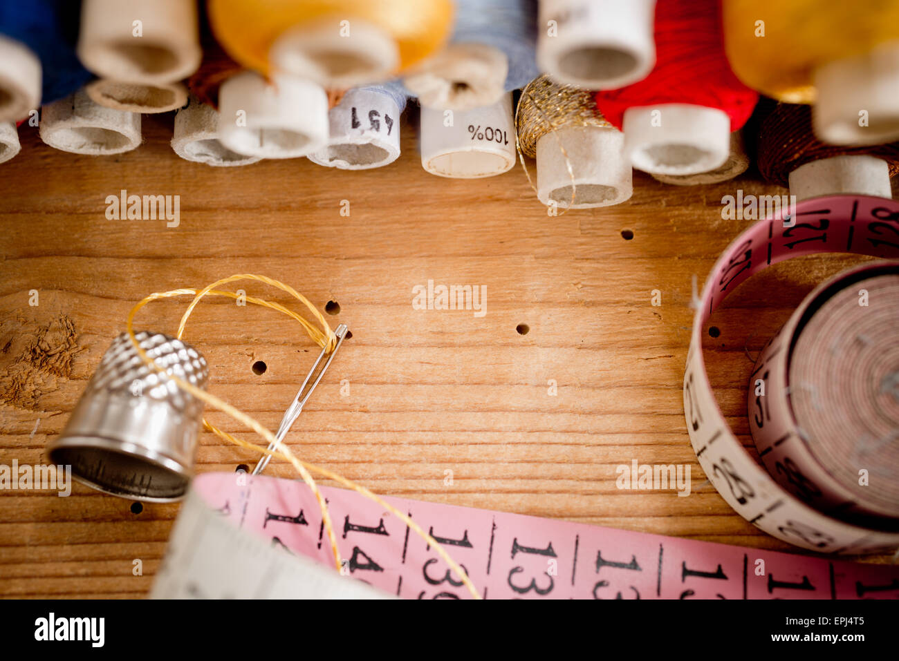 needle with thread and tape measure on the wooden desk Stock Photo - Alamy