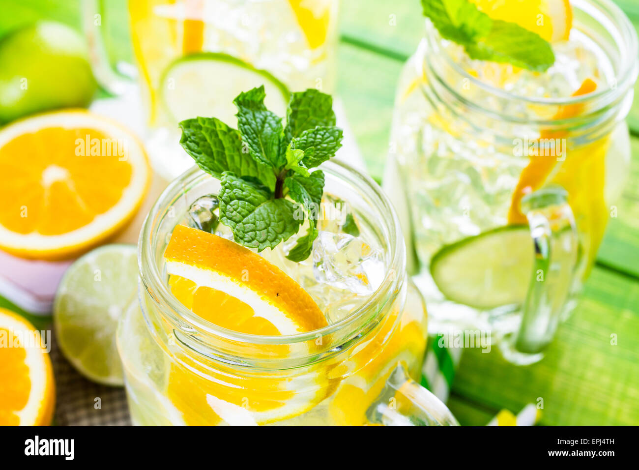 Infused water with fresh citrus fruits and ice Stock Photo - Alamy