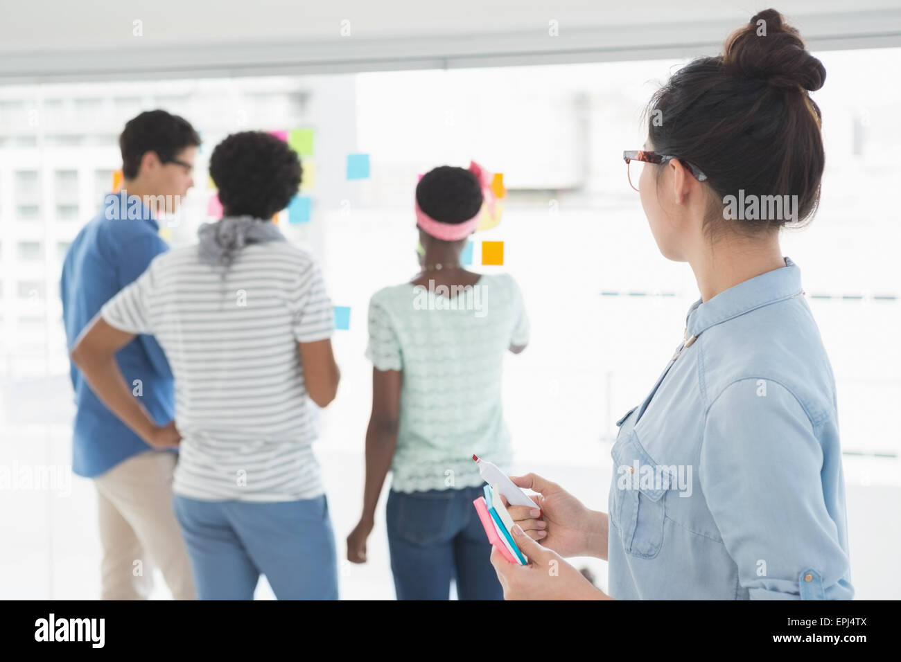 Young creative woman looking at team Stock Photo - Alamy