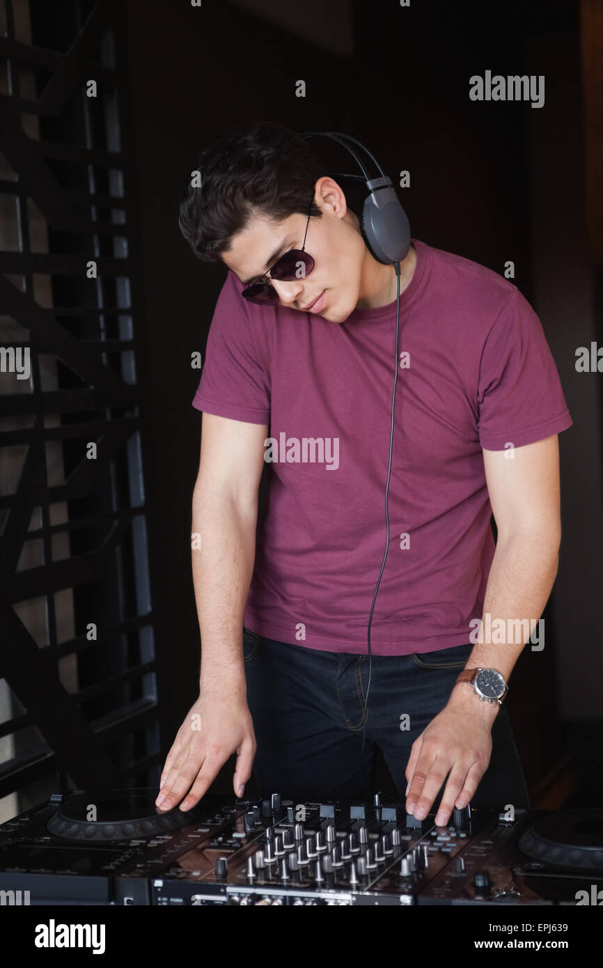 Cool dj in sunglasses working on a sound mixing desk Stock Photo - Alamy