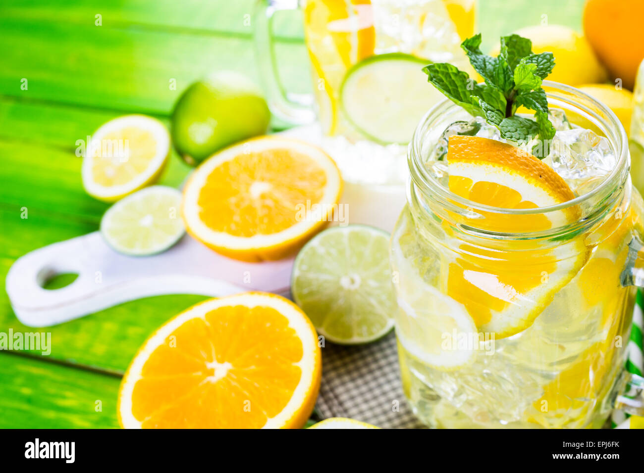 Infused water with fresh citrus fruits and ice Stock Photo - Alamy
