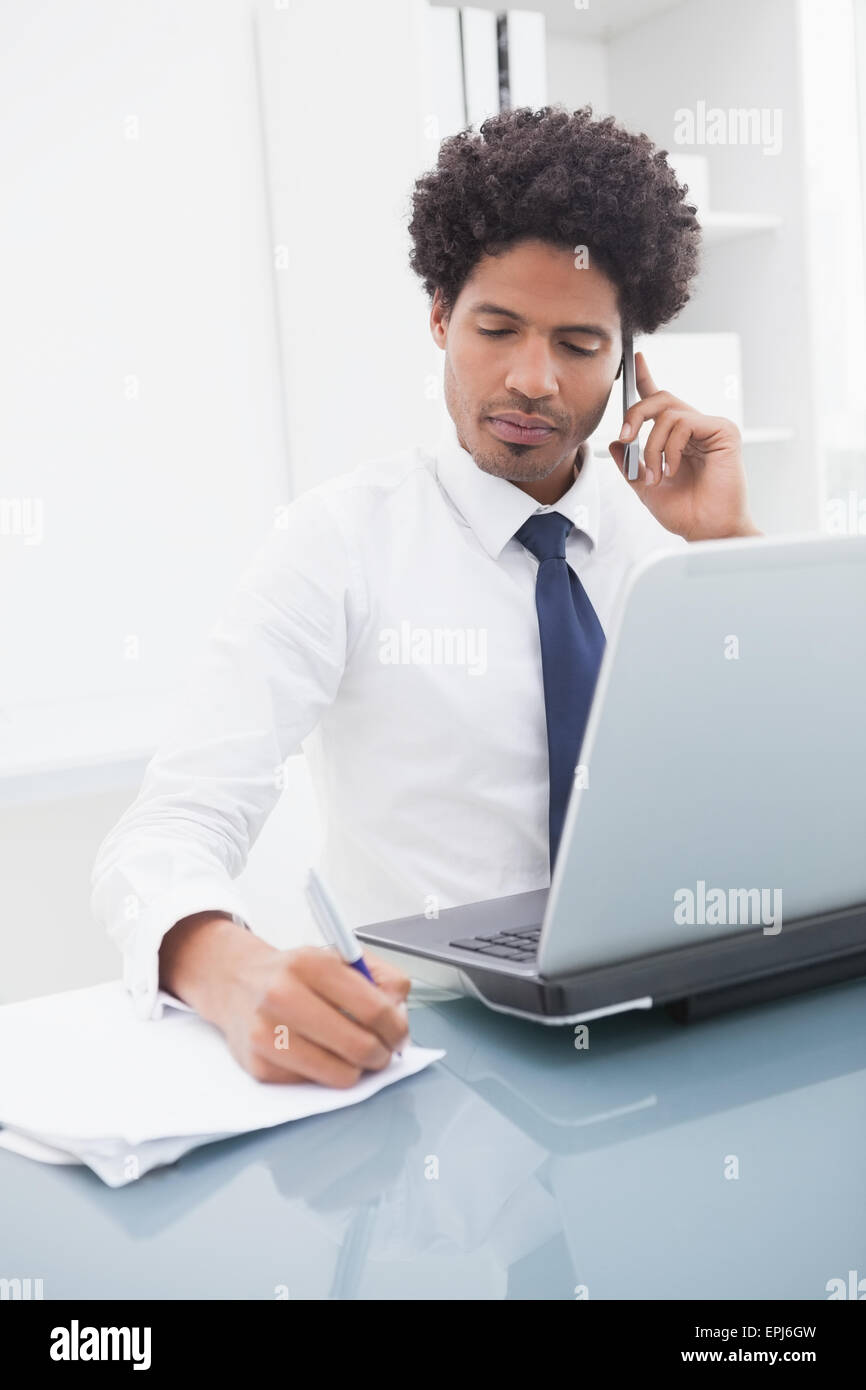 Serious businessman phoning and taking notes Stock Photo - Alamy