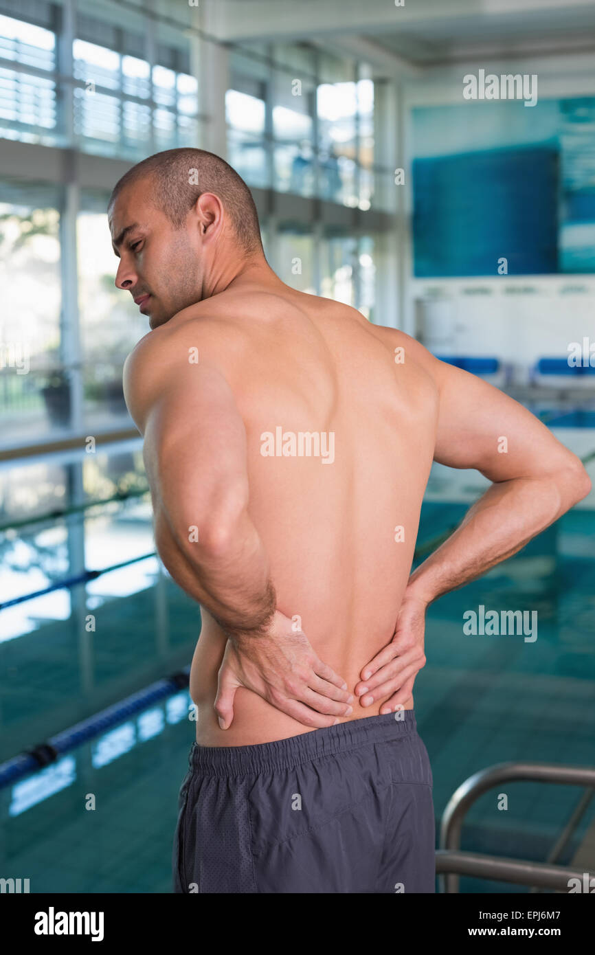 Rear view of shirtless swimmer with back ache by pool Stock Photo - Alamy
