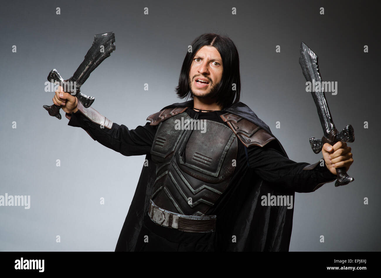 Angry knight with sword against dark background Stock Photo - Alamy
