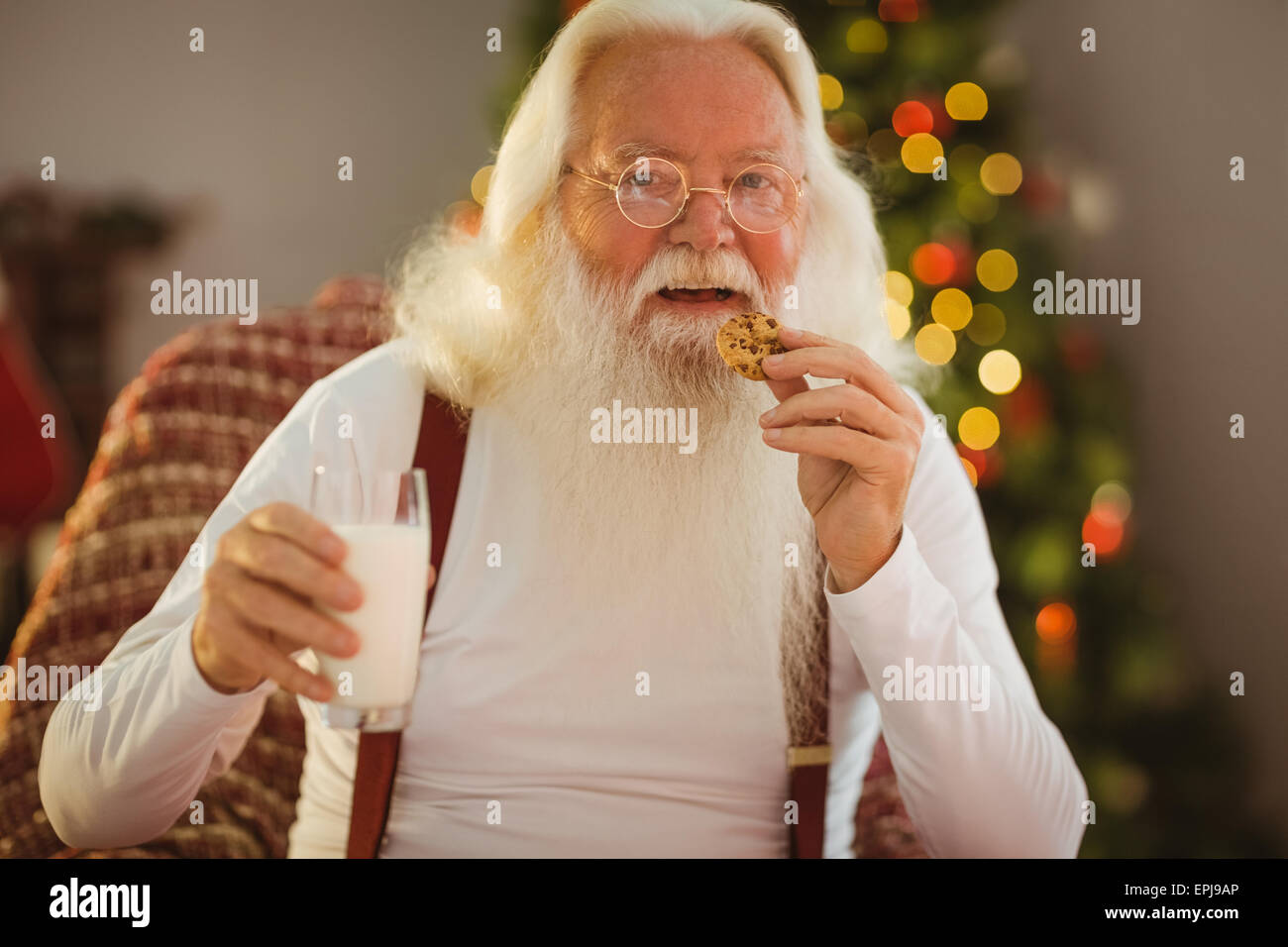 Smiling santa claus eating a cookie Stock Photo - Alamy