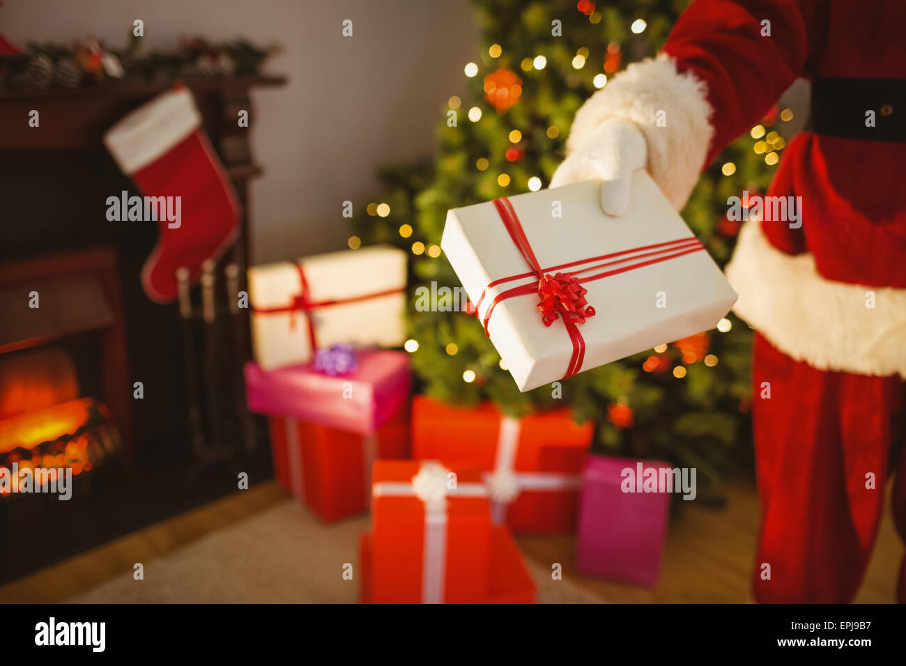 Mid section of santa delivering presents Stock Photo - Alamy