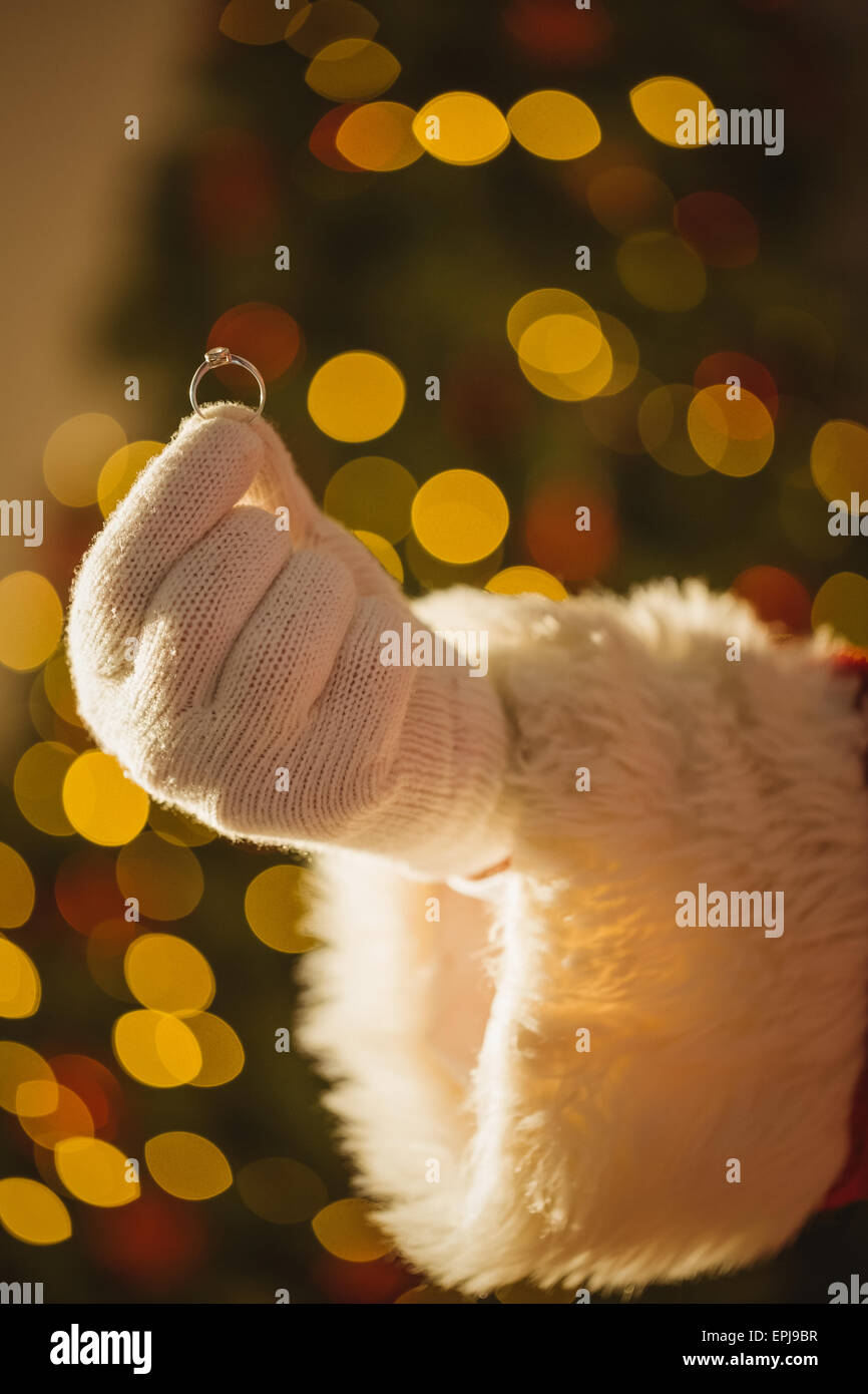 Hand of santa holding engagement ring Stock Photo - Alamy