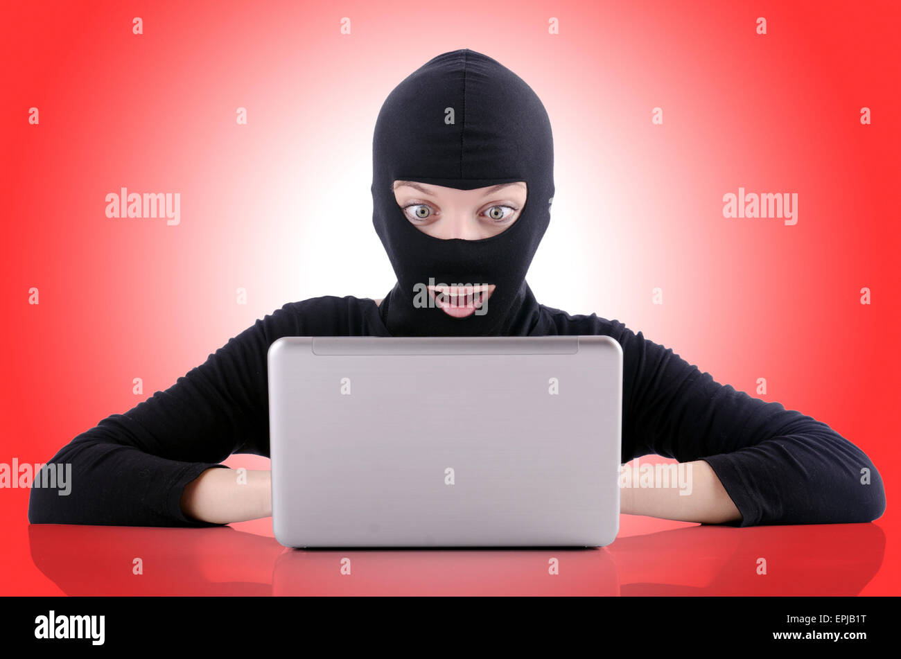 Hacker with computer wearing balaclava Stock Photo - Alamy