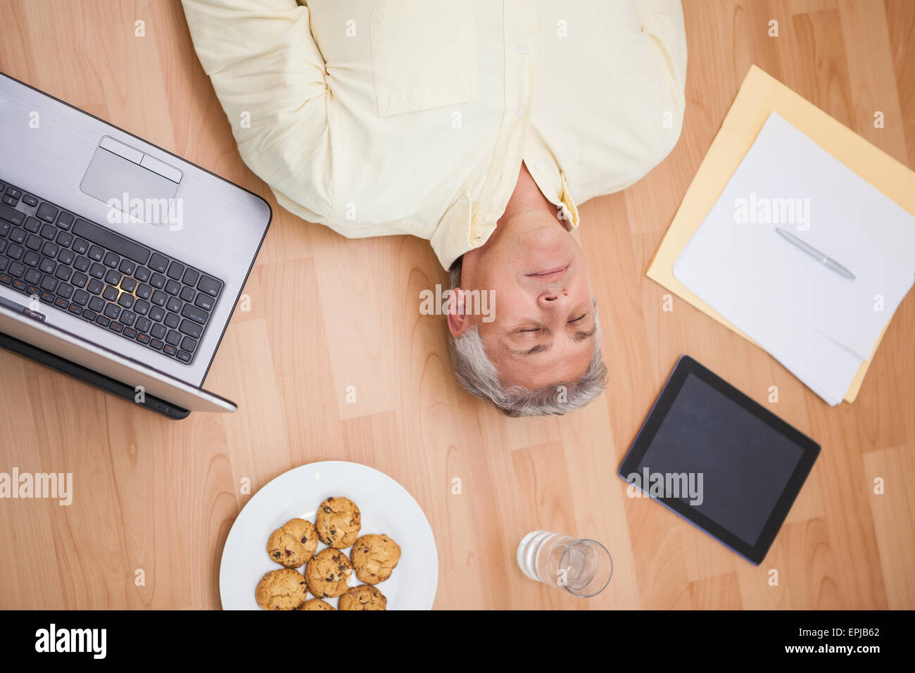 Man lying on floor surrounded by various objects Stock Photo - Alamy
