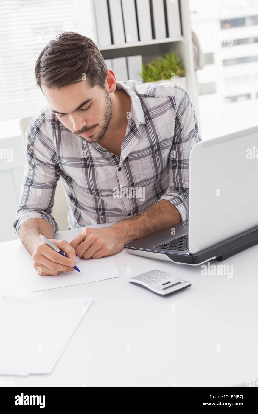 Casual businessman writing at his desk Stock Photo - Alamy