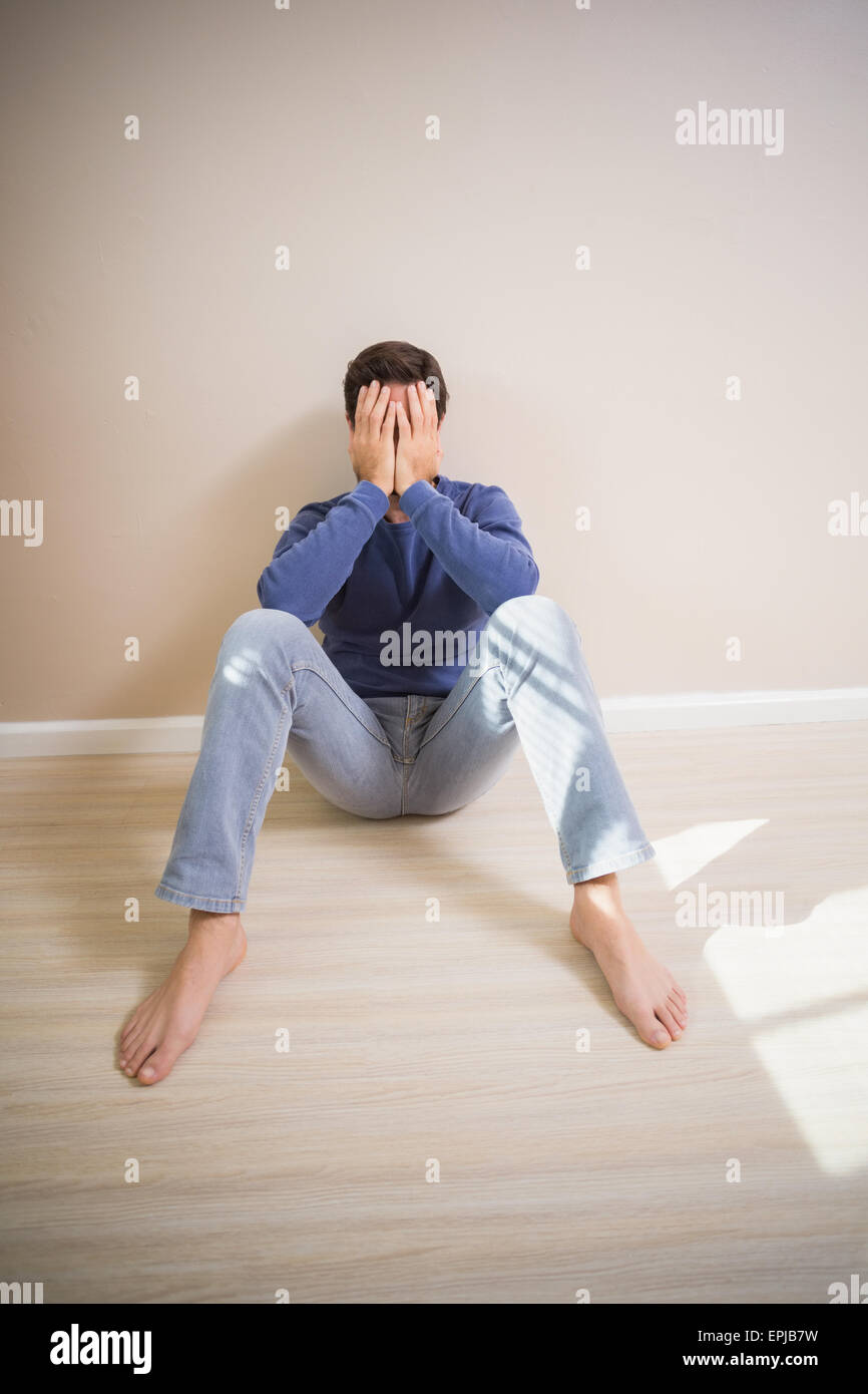 Depressed man sitting on floor Stock Photo - Alamy