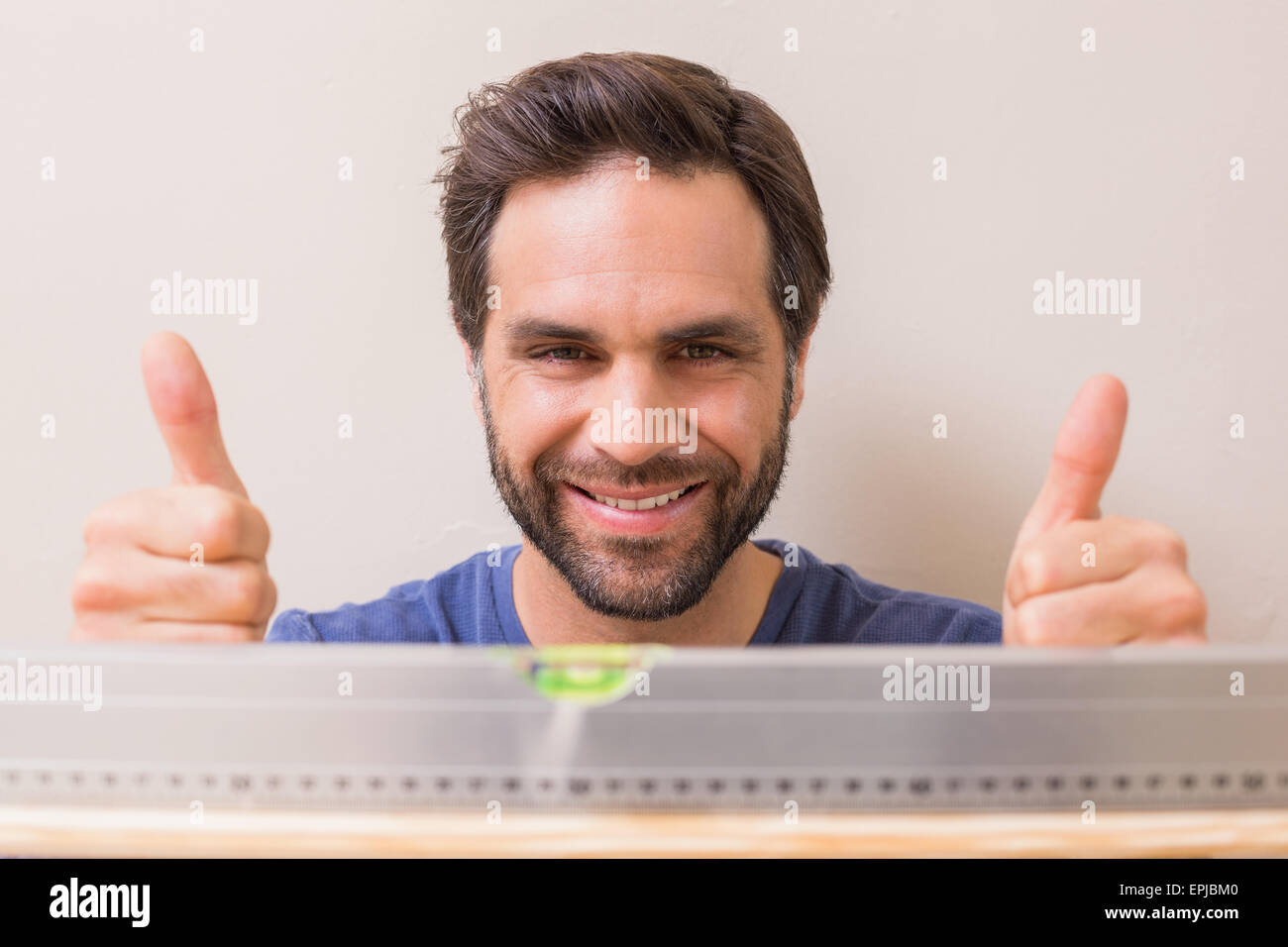 Casual man using spirit level Stock Photo - Alamy