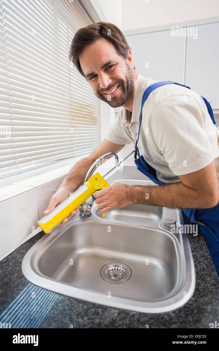 Plumber putting filling in between tiles Stock Photo - Alamy