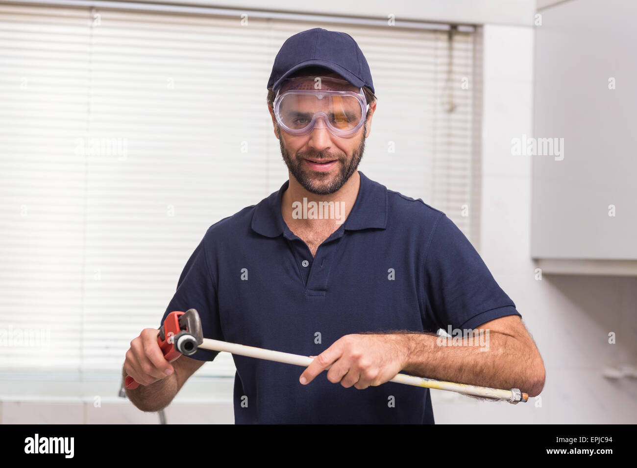 Plumber fixing pipe with wrench Stock Photo - Alamy