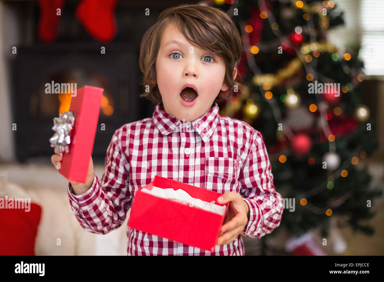 Surprised little boy holding a gift Stock Photo - Alamy