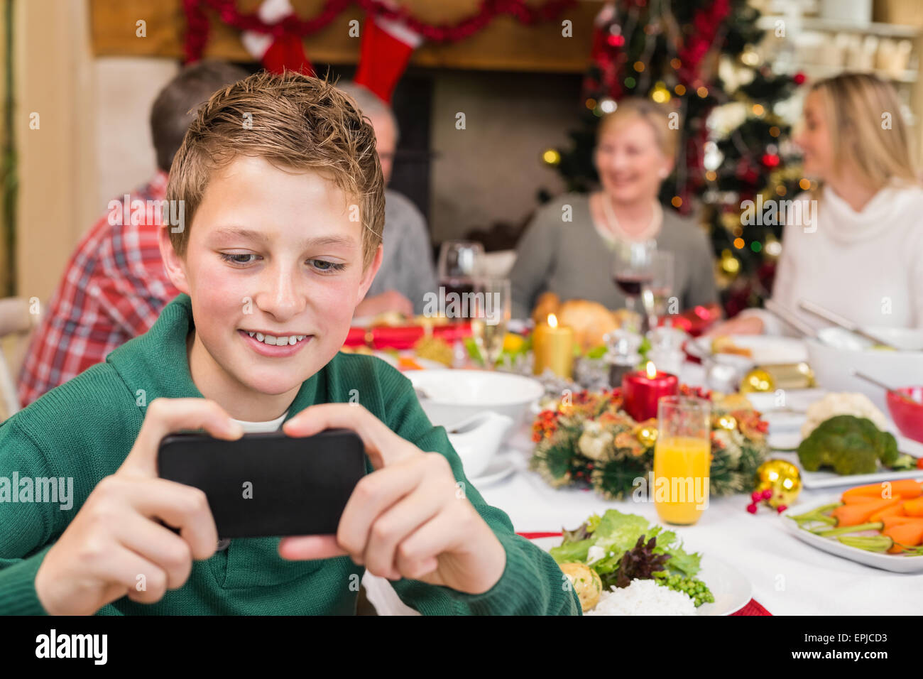 Young boy holding smartphone during christmas dinner Stock Photo - Alamy