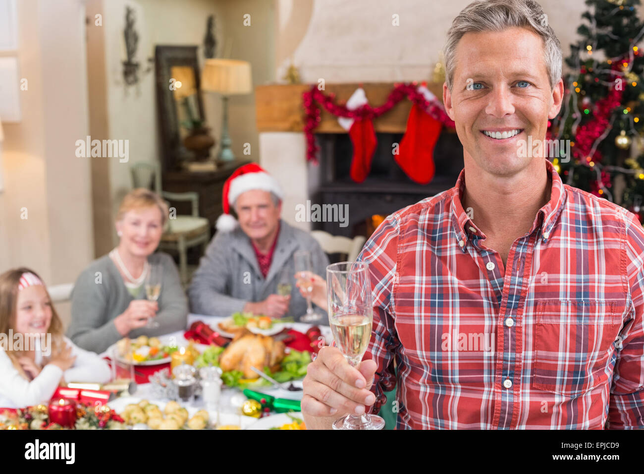 Smiling father toasting at camera in front of his family Stock Photo ...