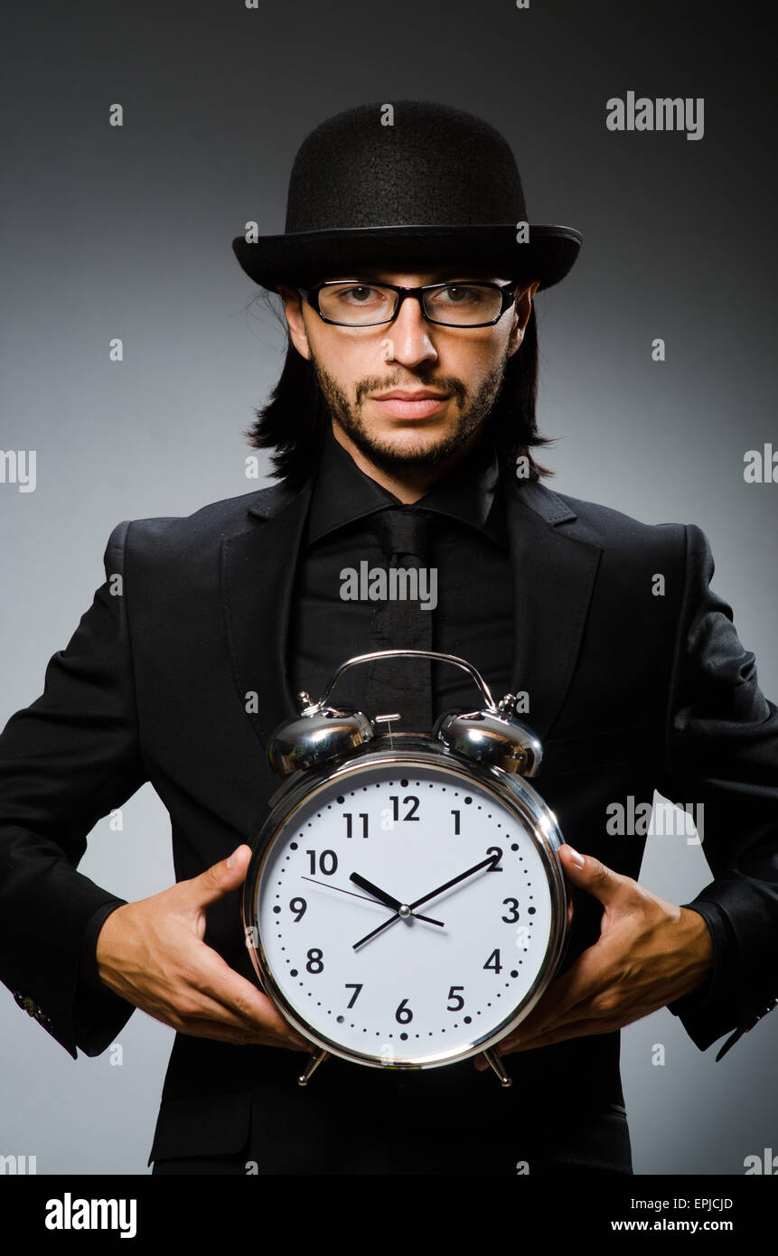 Man with clock wearing vintage hat Stock Photo - Alamy